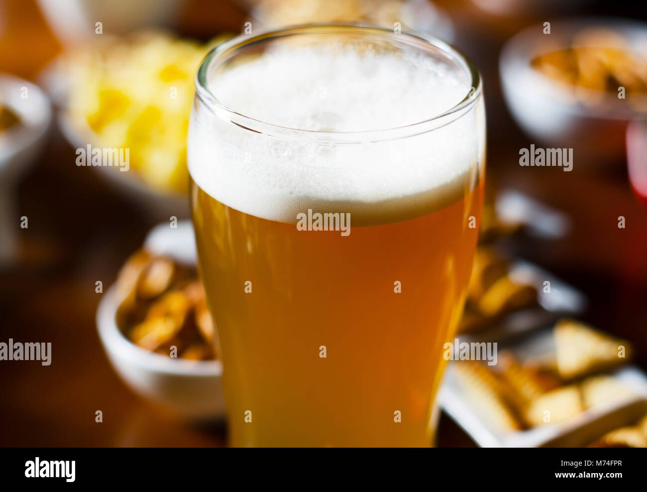 pint of lager beer in a glass, set of various snacks, a standard set of ...