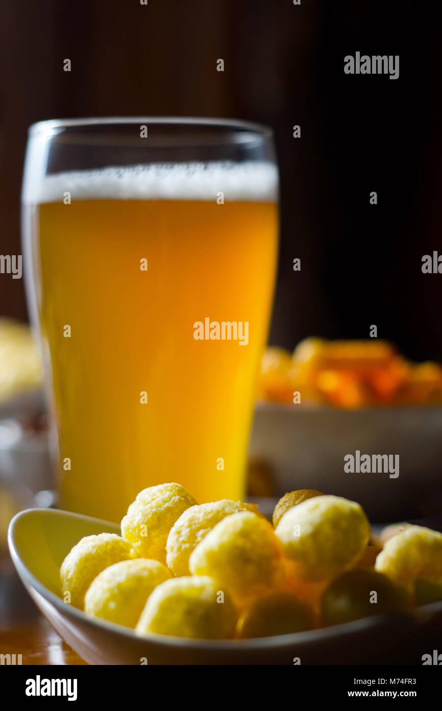 pint of lager beer in a glass, set of various snacks, a standard set of ...