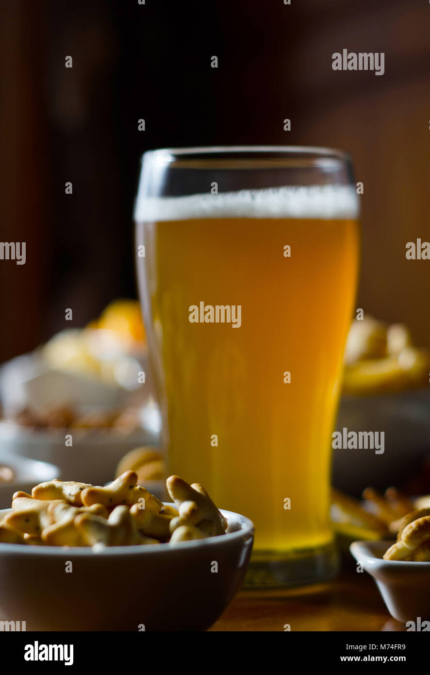 pint of lager beer in a glass, set of various snacks, a standard set of ...