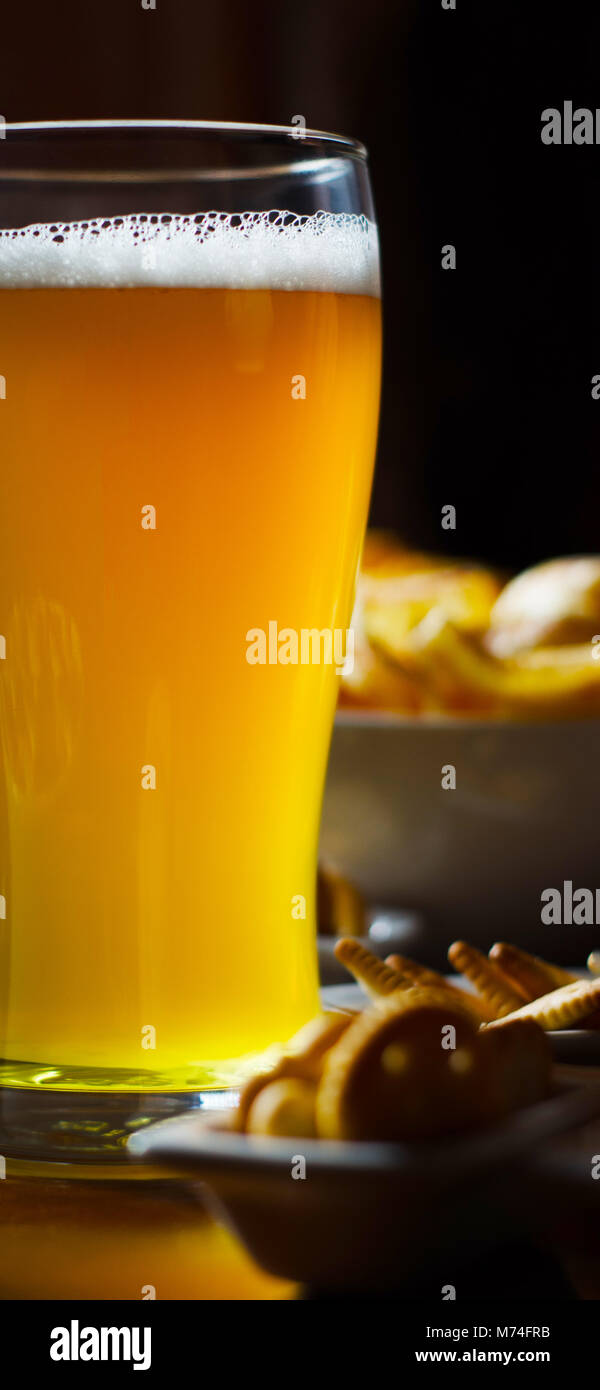 pint of lager beer in a glass, set of various snacks, a standard set of ...
