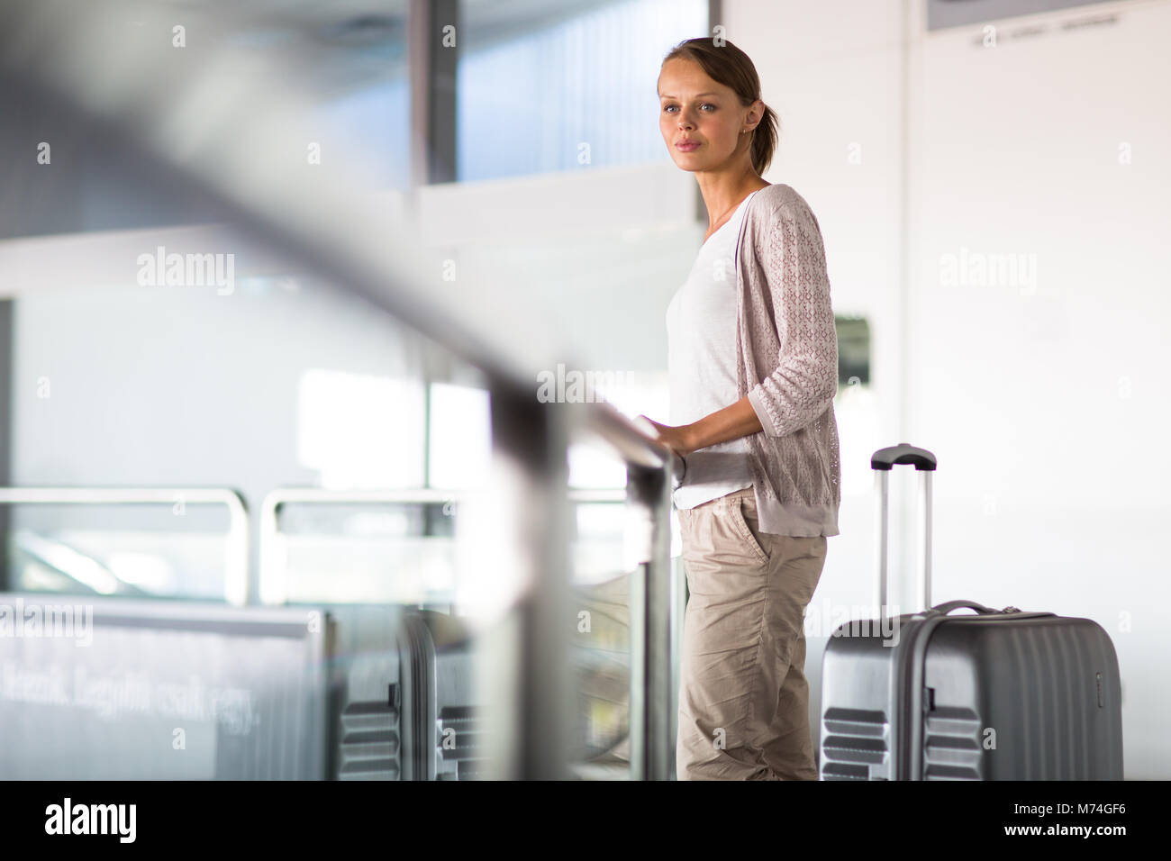 Young female passenger at the airport, about to check-in Stock Photo ...