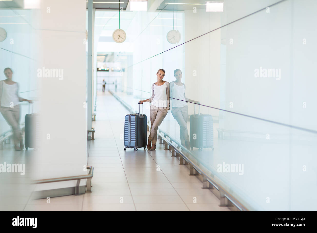 Young female passenger at the airport, waiting for her delayed flight ...
