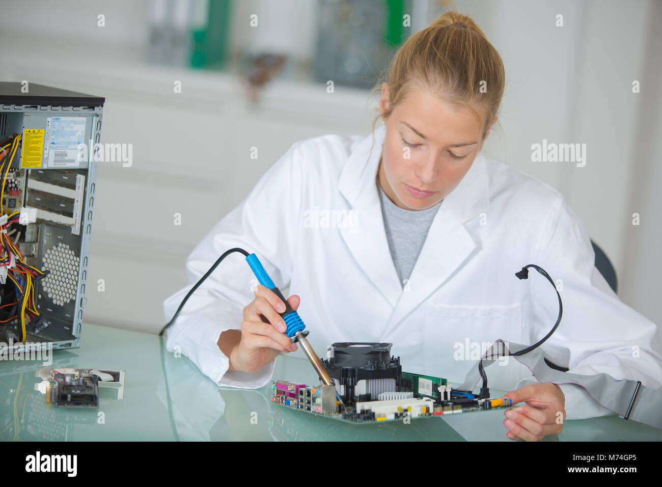 female pc technician soldering a chip from a desktop computer Stock ...