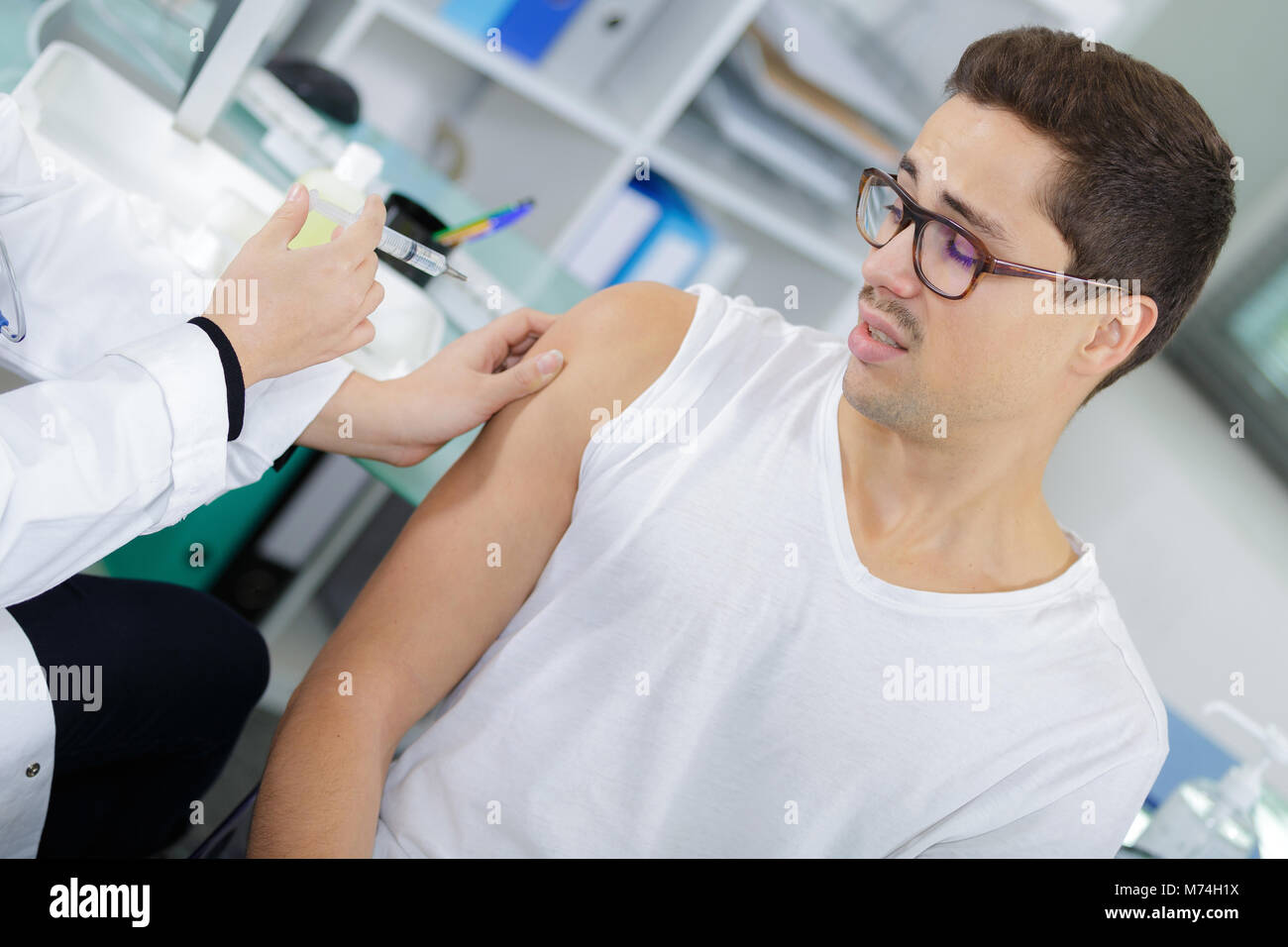 man nervously awaiting injection in arm Stock Photo - Alamy