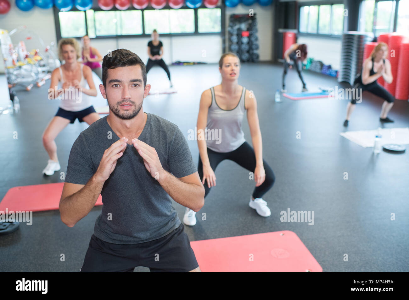 aerobics group members doing squat Stock Photo - Alamy