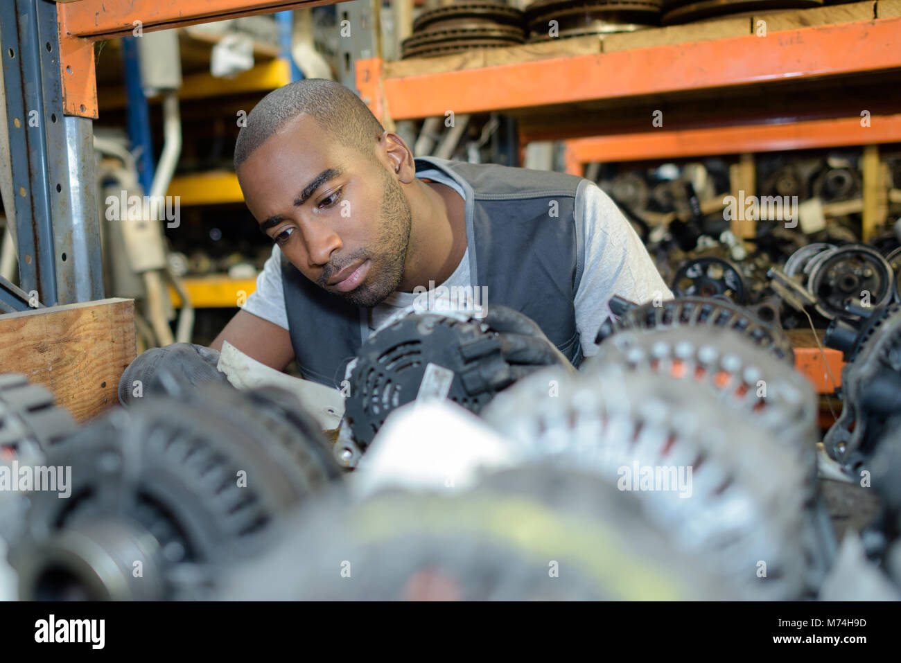 Man looking through parts in scrap yard Stock Photo - Alamy
