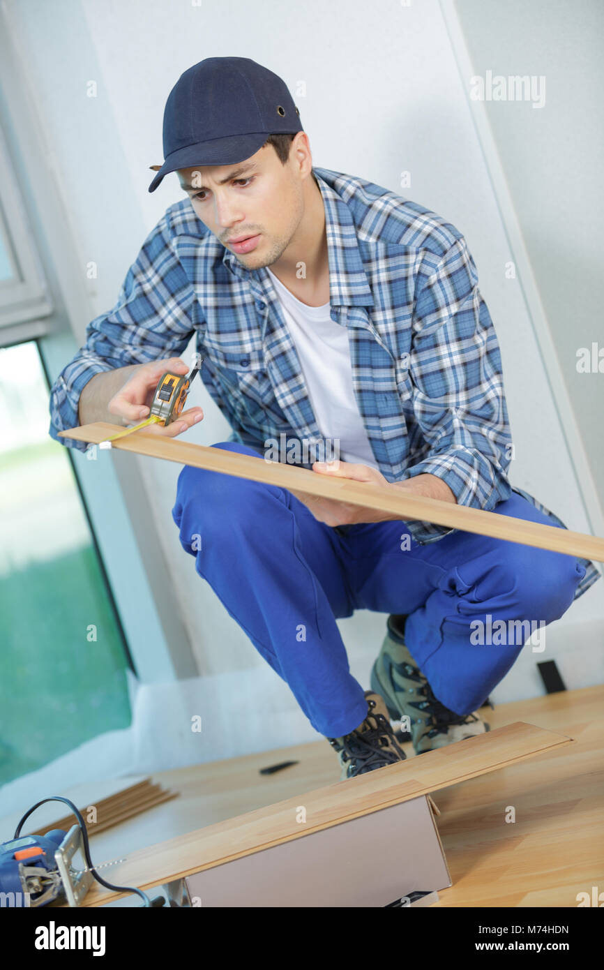 young technician installing floor at construction site Stock Photo - Alamy