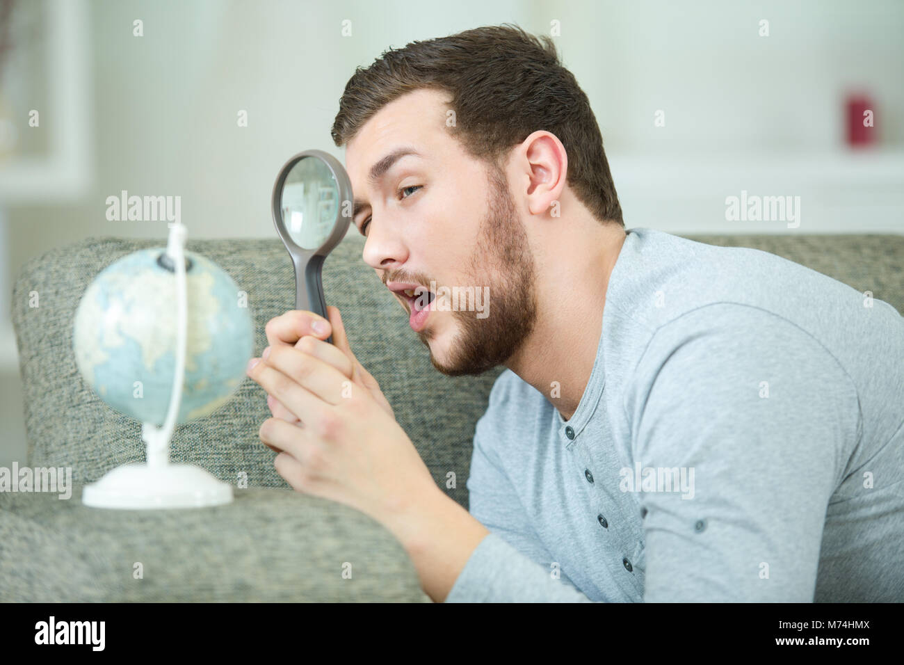 young man using a magnifying glass Stock Photo - Alamy