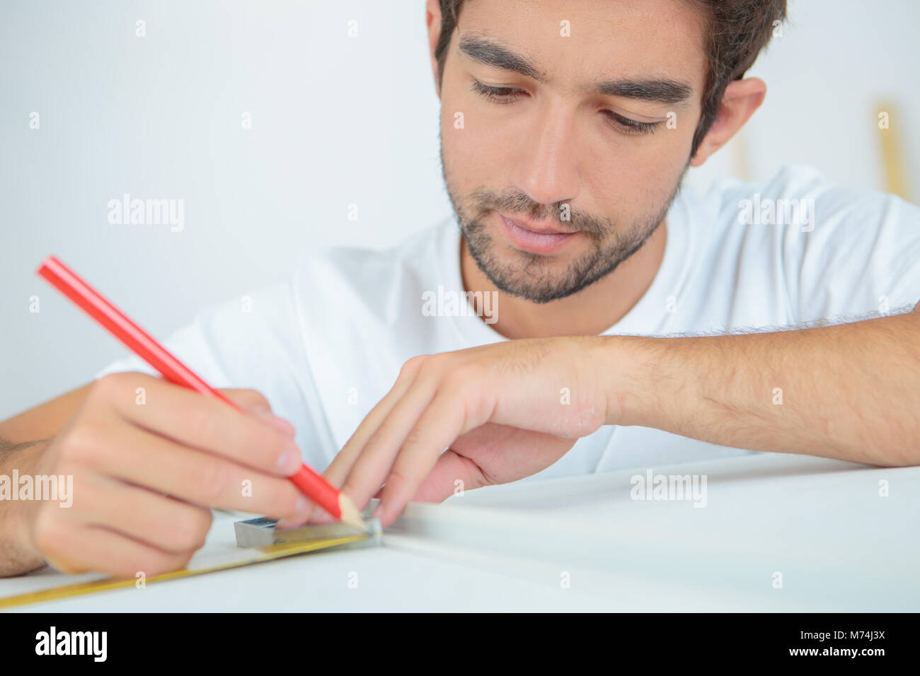 man marking an object using pencil Stock Photo - Alamy