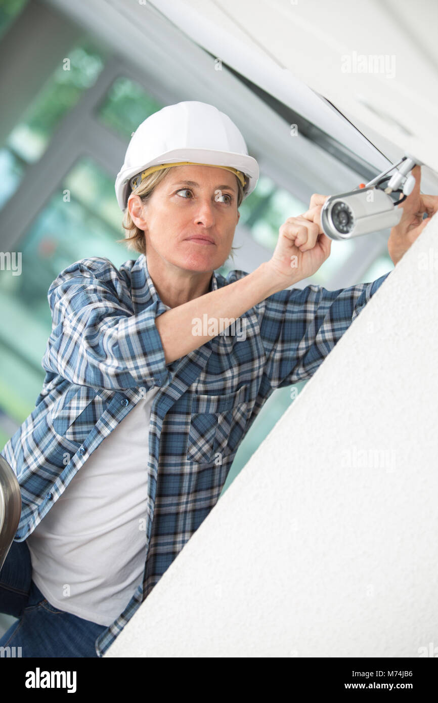female cctv installer holding security camera Stock Photo - Alamy
