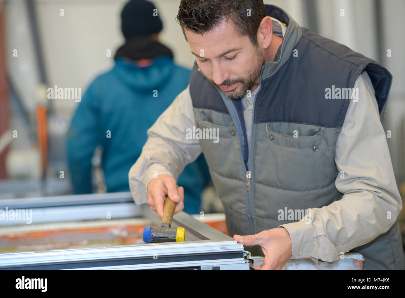 workman working on window frames at factory Stock Photo - Alamy