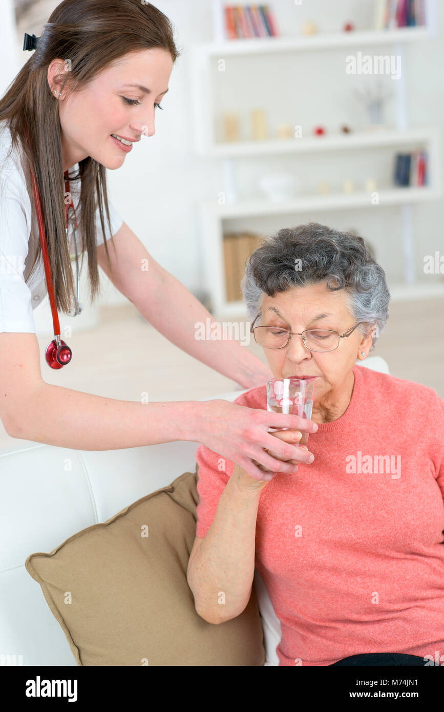 young pretty doctor giving the drugs to sick elderly woman Stock Photo ...