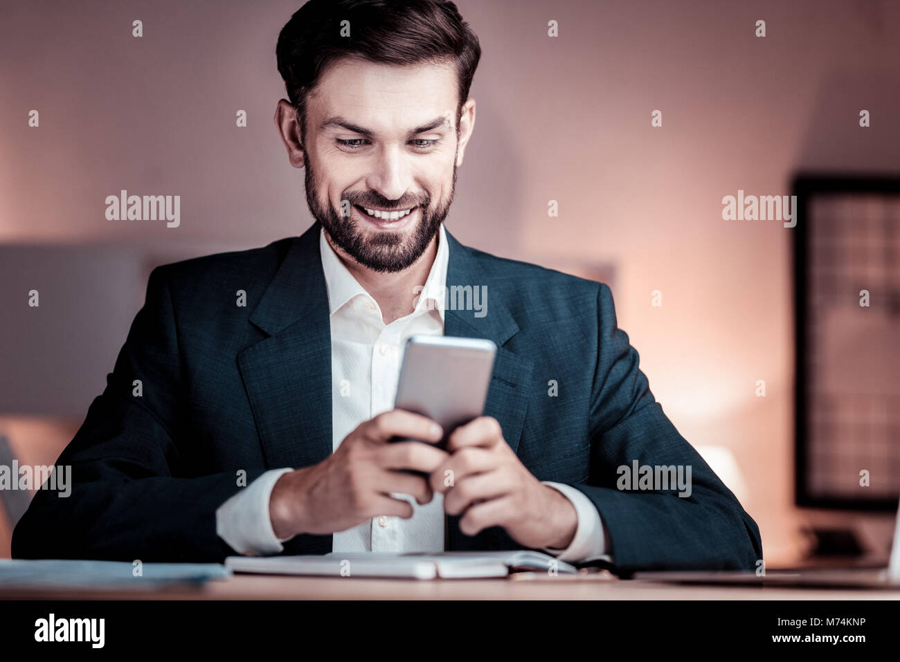 Happy interested man sitting and using the smartphone Stock Photo - Alamy