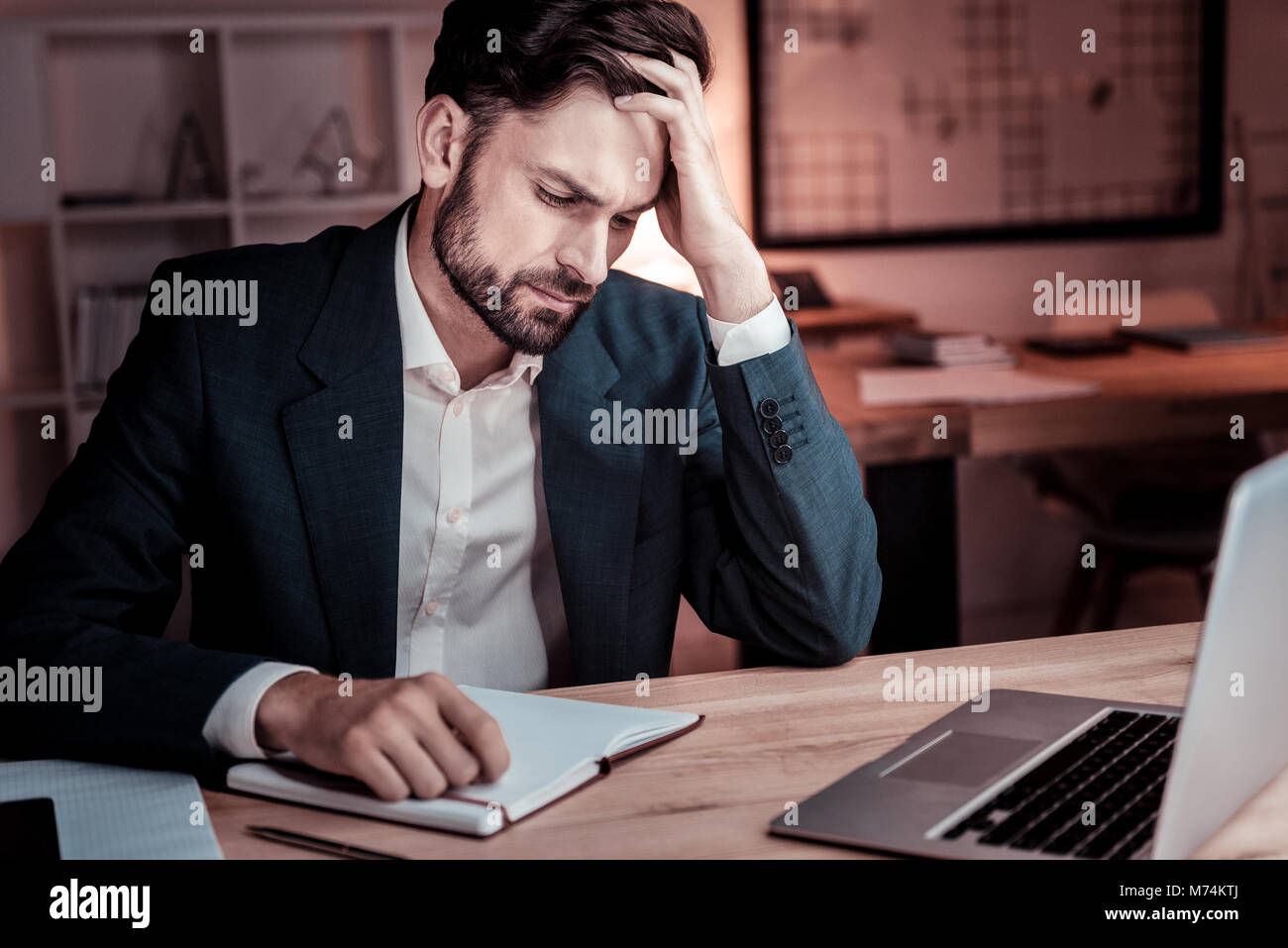 Upset deep man supporting his head sitting by the table Stock Photo - Alamy