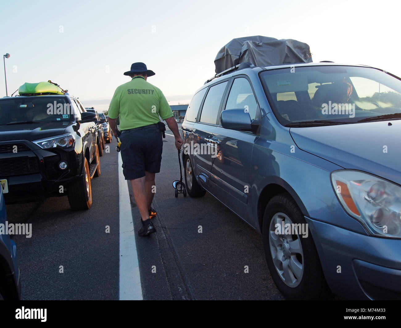 Security guard checks cards in queue for the auto ferry from Cape May ...