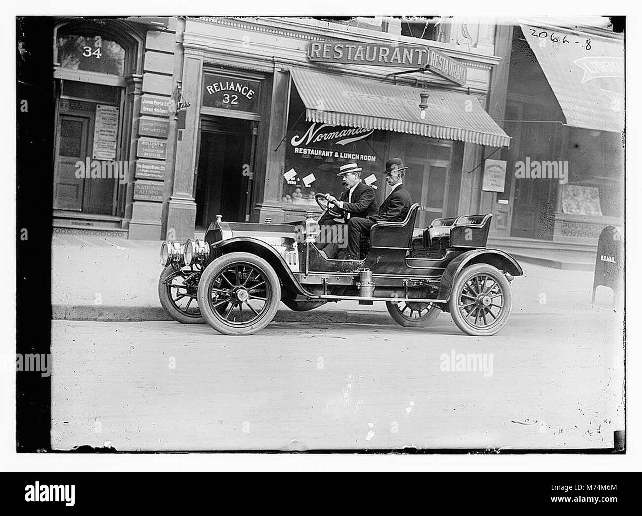 A photograph of G.G. Bain in an automobile in front of a restaurant ...