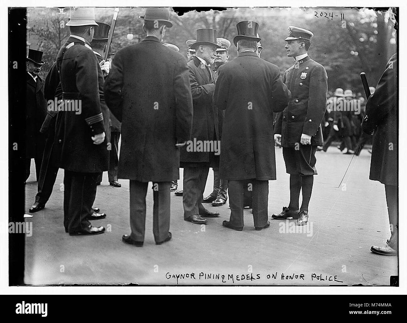 The photograph captures Gaynor awarding medals to honor police officers ...