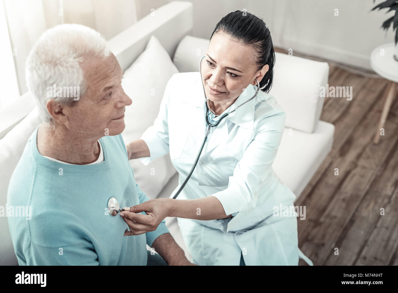Cute experienced nurse sitting and examining her patient Stock Photo ...