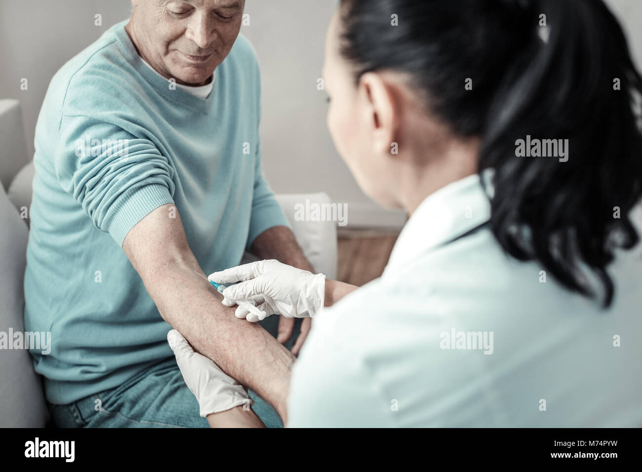 Aged senior patient sitting and having injection Stock Photo - Alamy