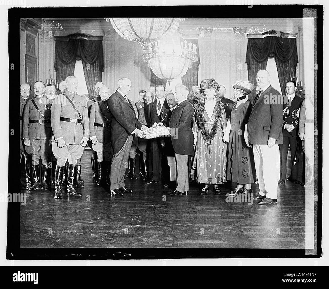 A photograph capturing President Warren G. Harding receiving a flag on ...