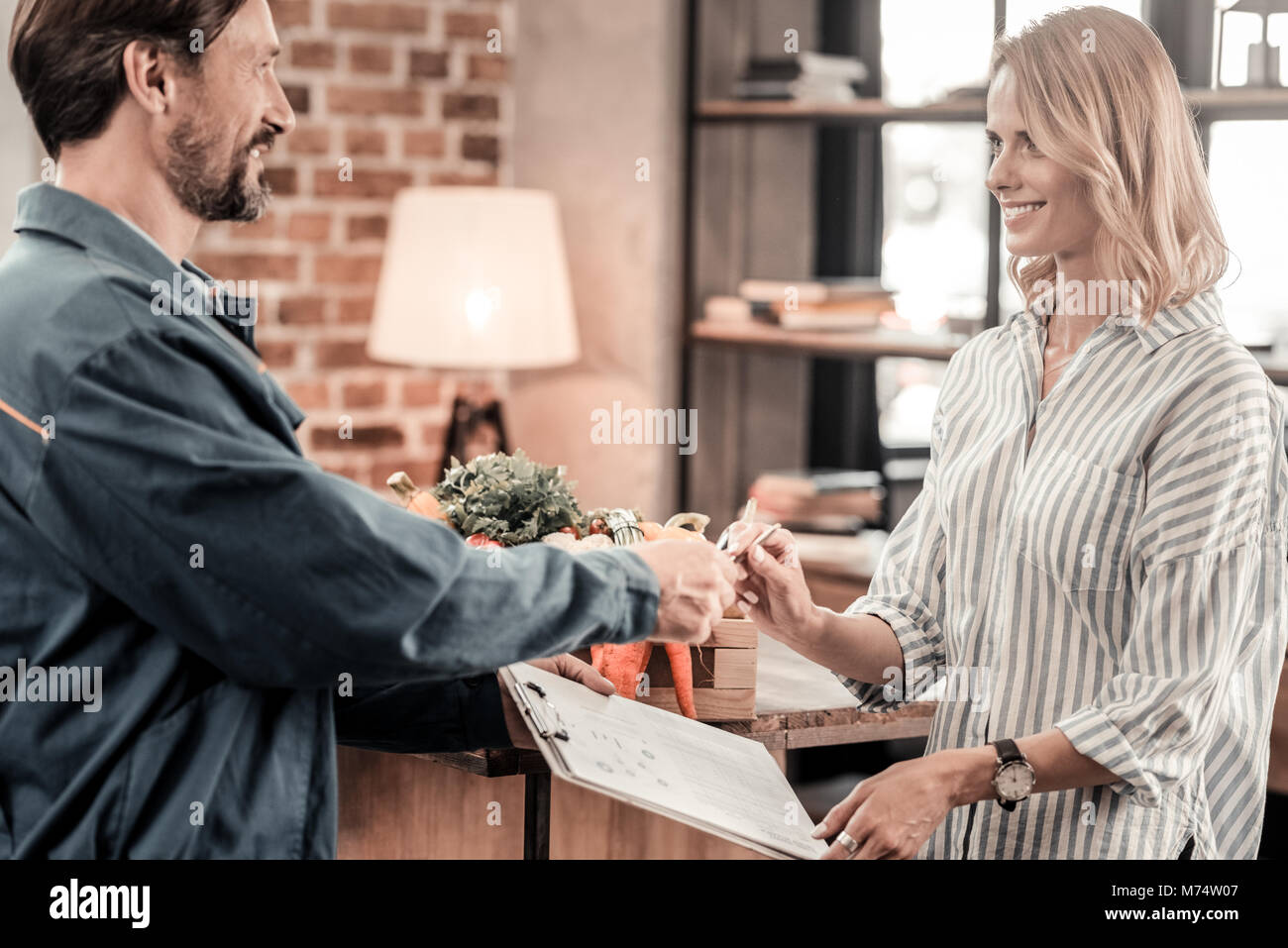 Nice young woman taking a pen Stock Photo - Alamy