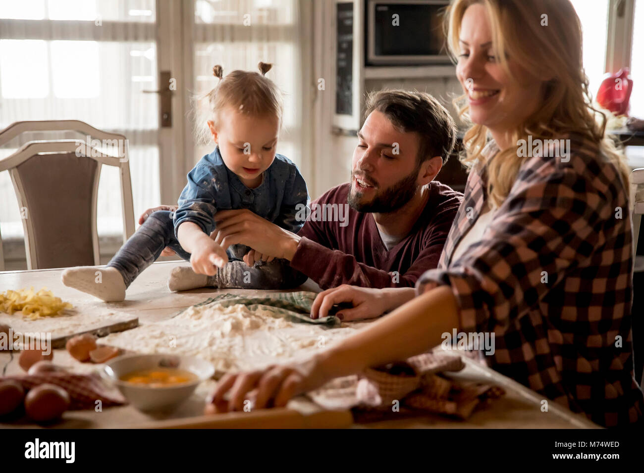 Happy family making pasta in the kitchen at home Stock Photo - Alamy