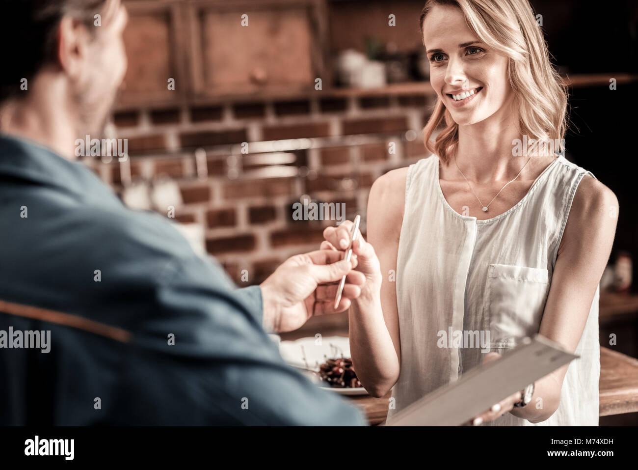 Delighted nice woman taking a pen Stock Photo - Alamy