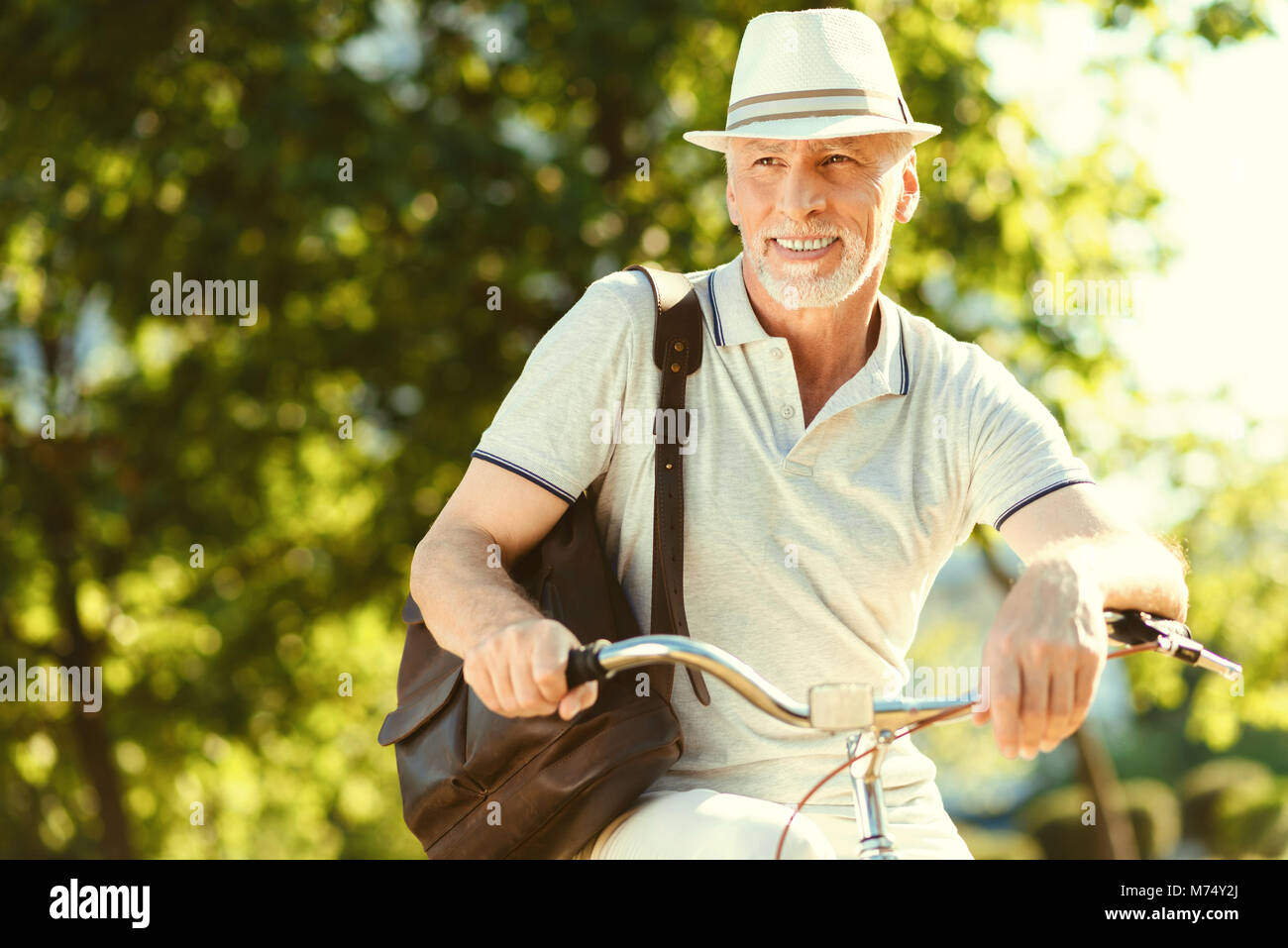 Happy aged man riding a bike Stock Photo - Alamy