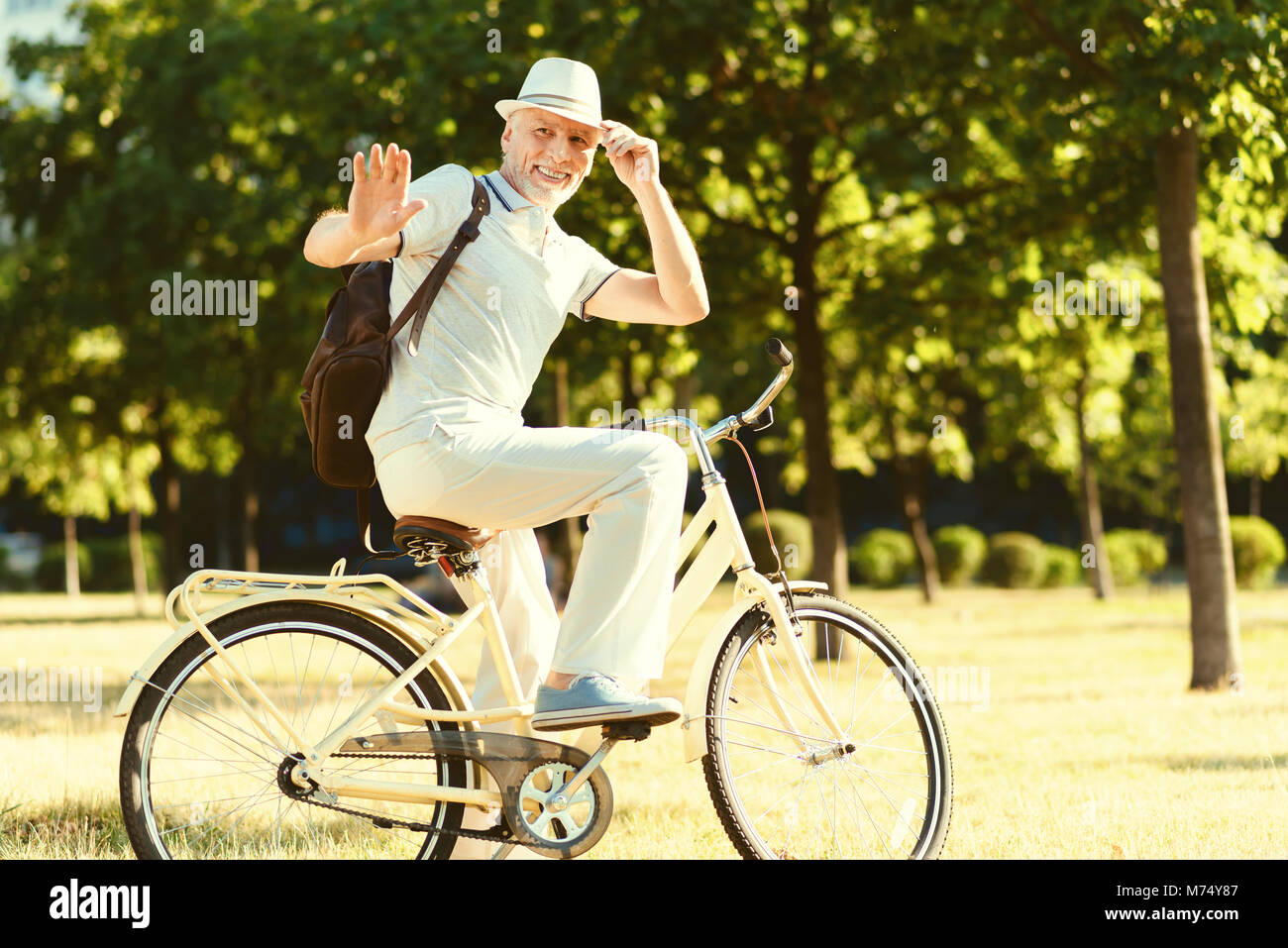 Nice delighted man riding a bike Stock Photo - Alamy