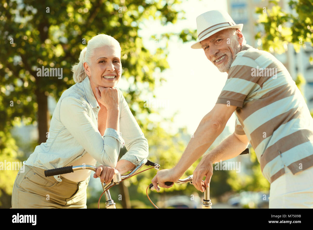 Positive aged couple riding bikes together Stock Photo - Alamy