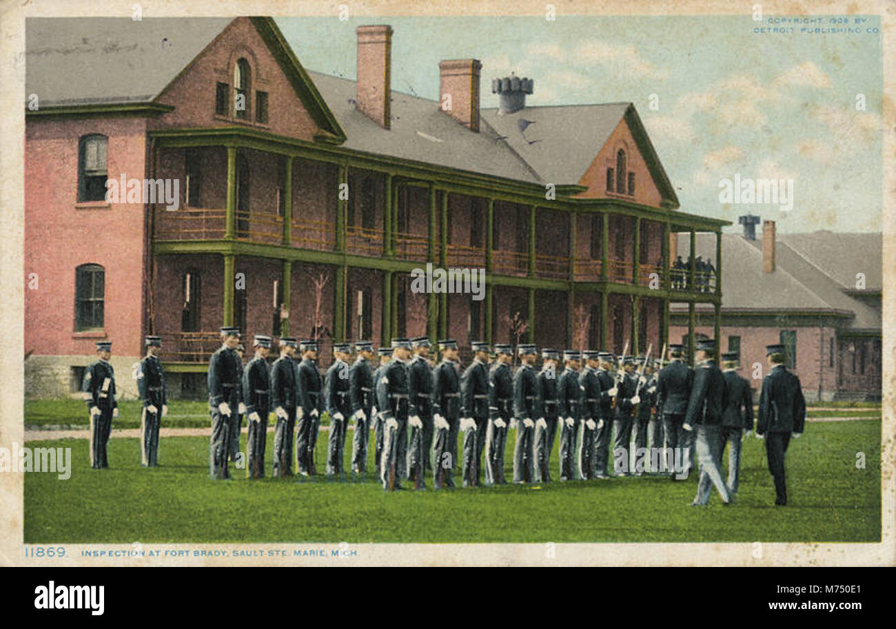 The photograph captures a military inspection at Fort Brady, an ...