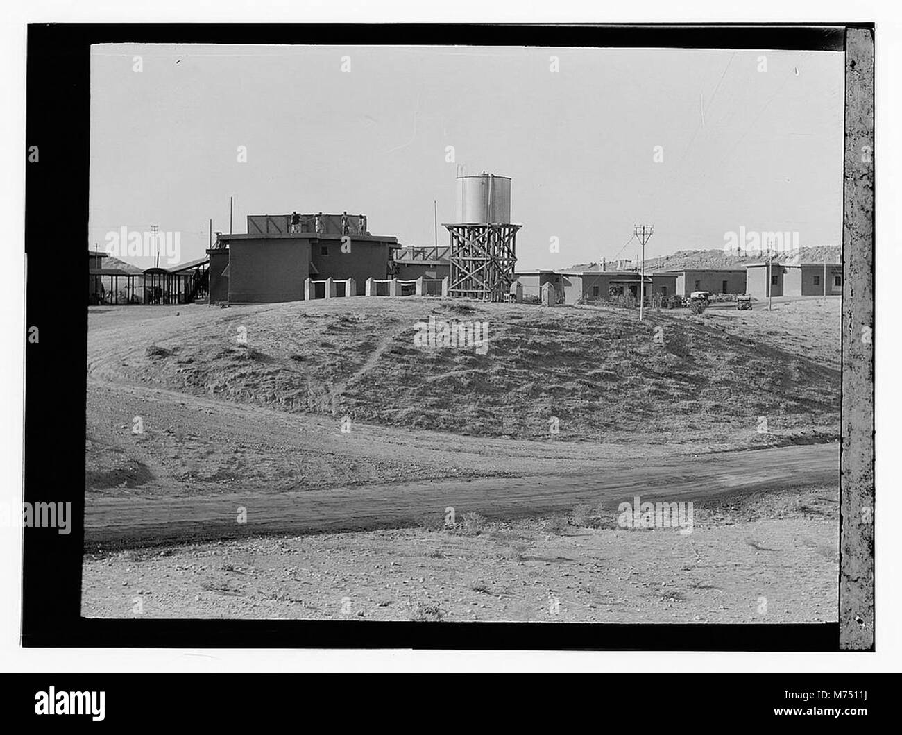 A photograph showing oil fields in Iraq with a water tower in the ...