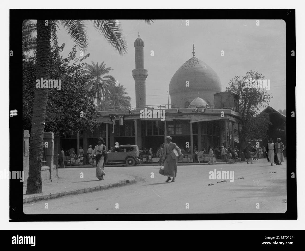 A street scene in Baghdad, Iraq, with the Midan Mosque visible in the ...
