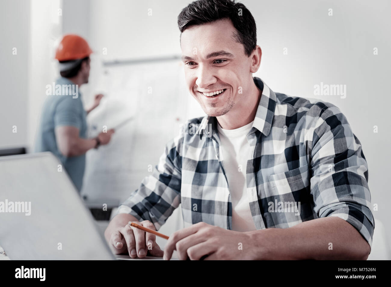 Joyful young man being glad to work here Stock Photo - Alamy