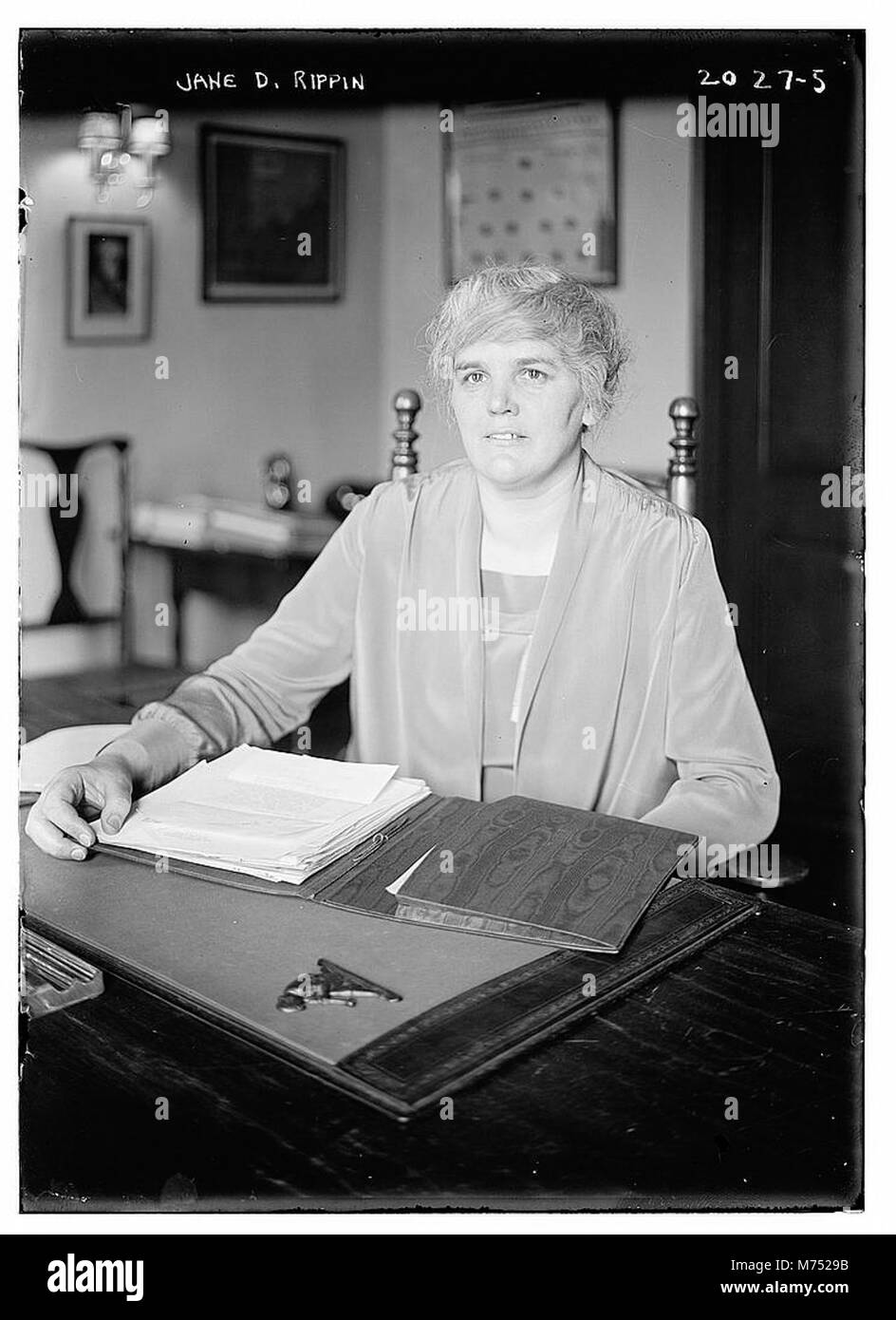 A photograph of Jane D. Rippin, seated at a desk with papers ...