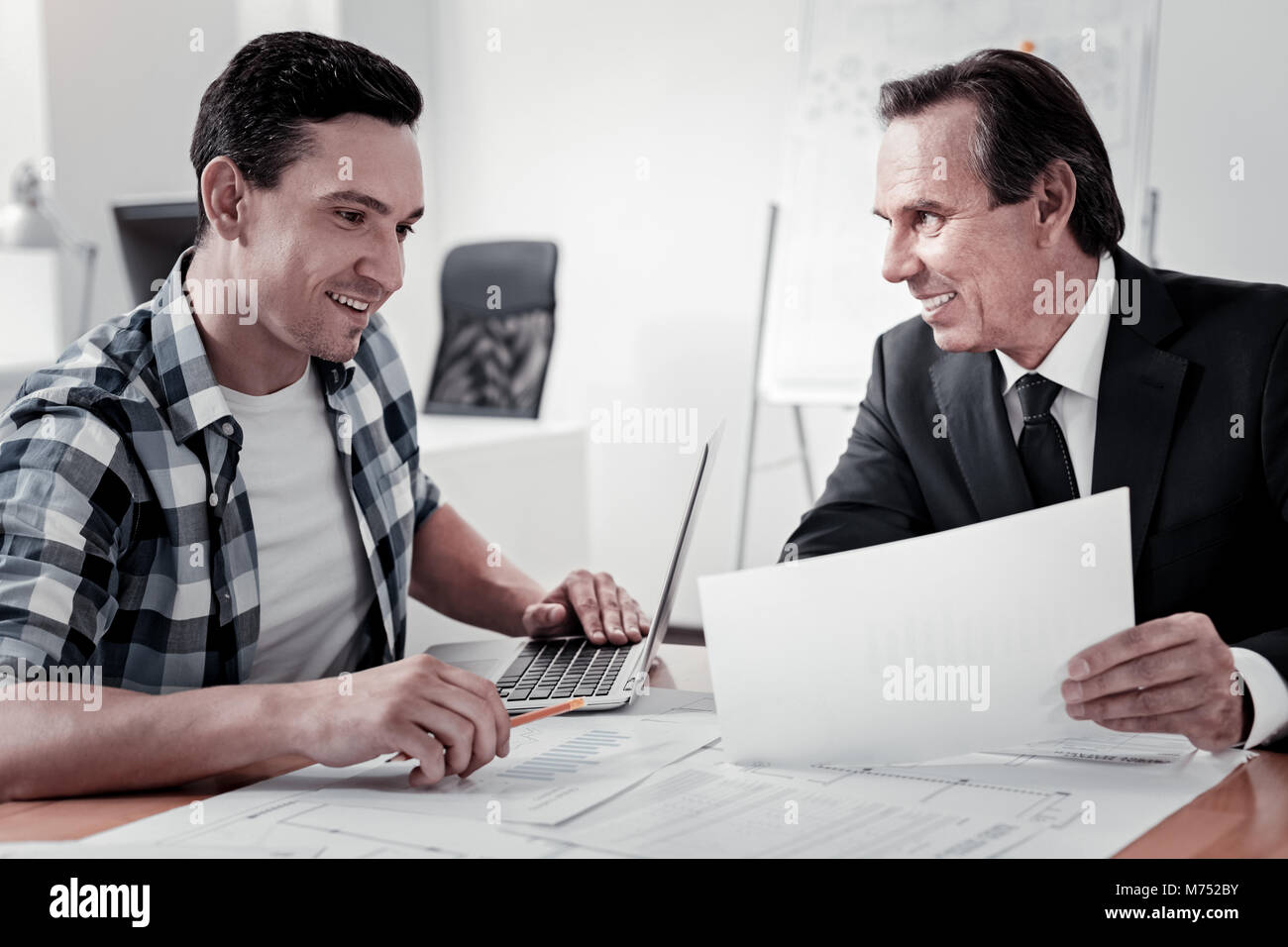 Positive young man looking at document Stock Photo - Alamy