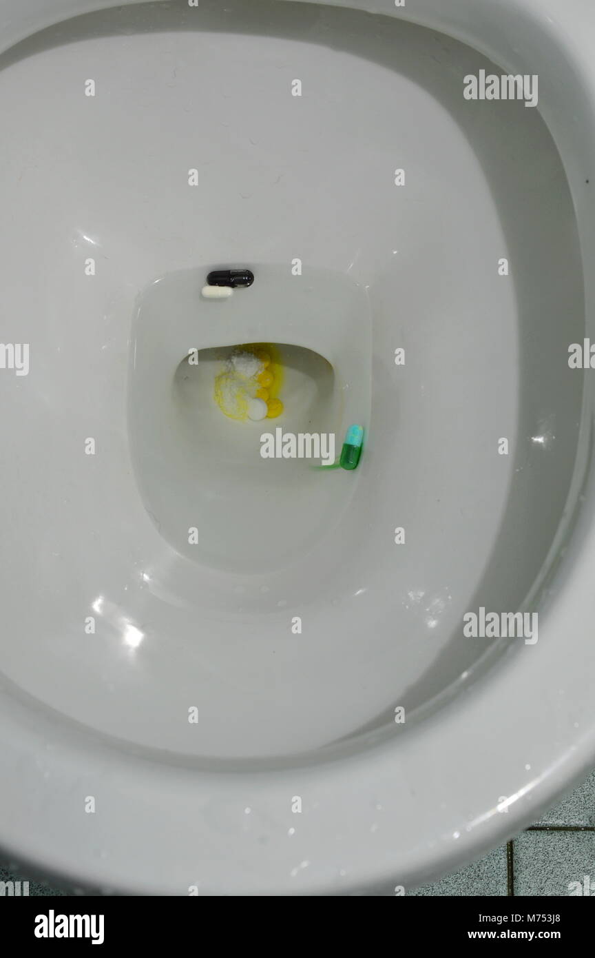 drug dropping in toilet flush Stock Photo - Alamy