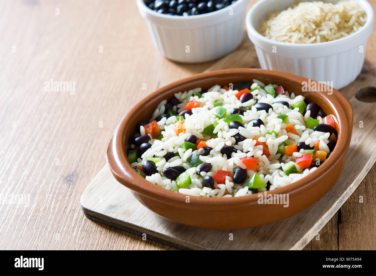 Traditional cuban rice, black beans and pepper on wooden table ...