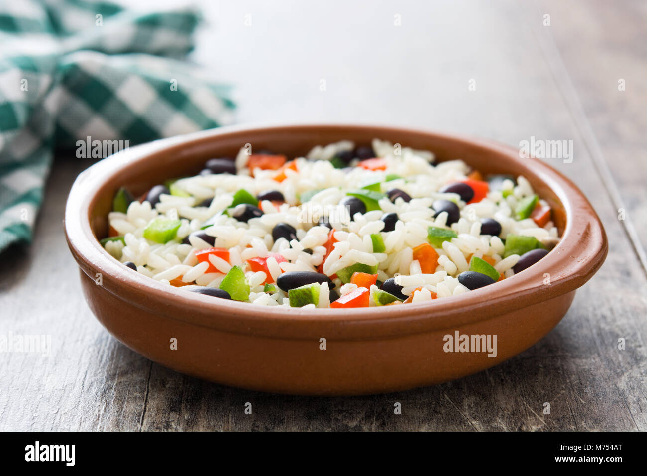 Traditional cuban rice, black beans and pepper on wooden table ...