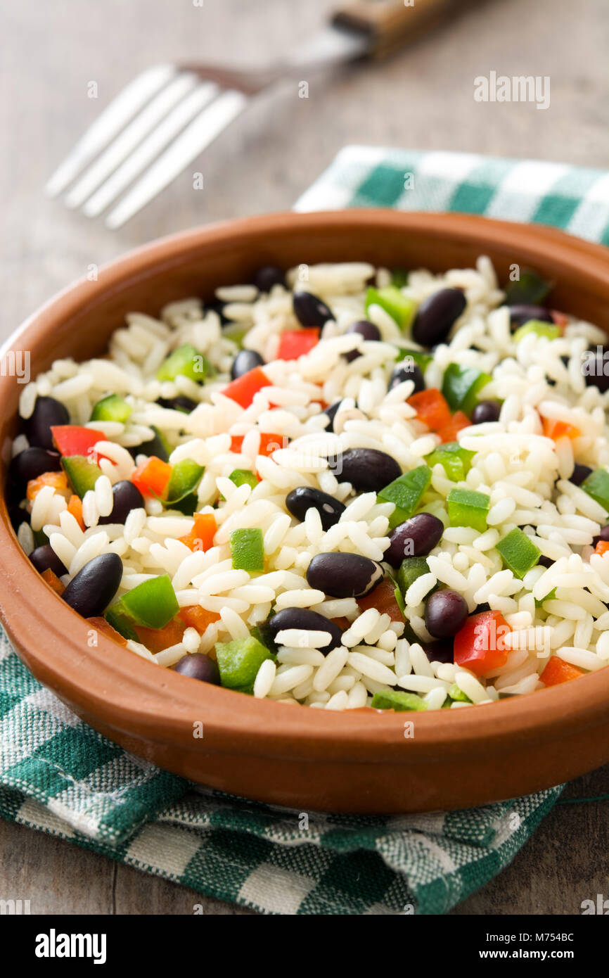 Traditional cuban rice, black beans and pepper on wooden table ...