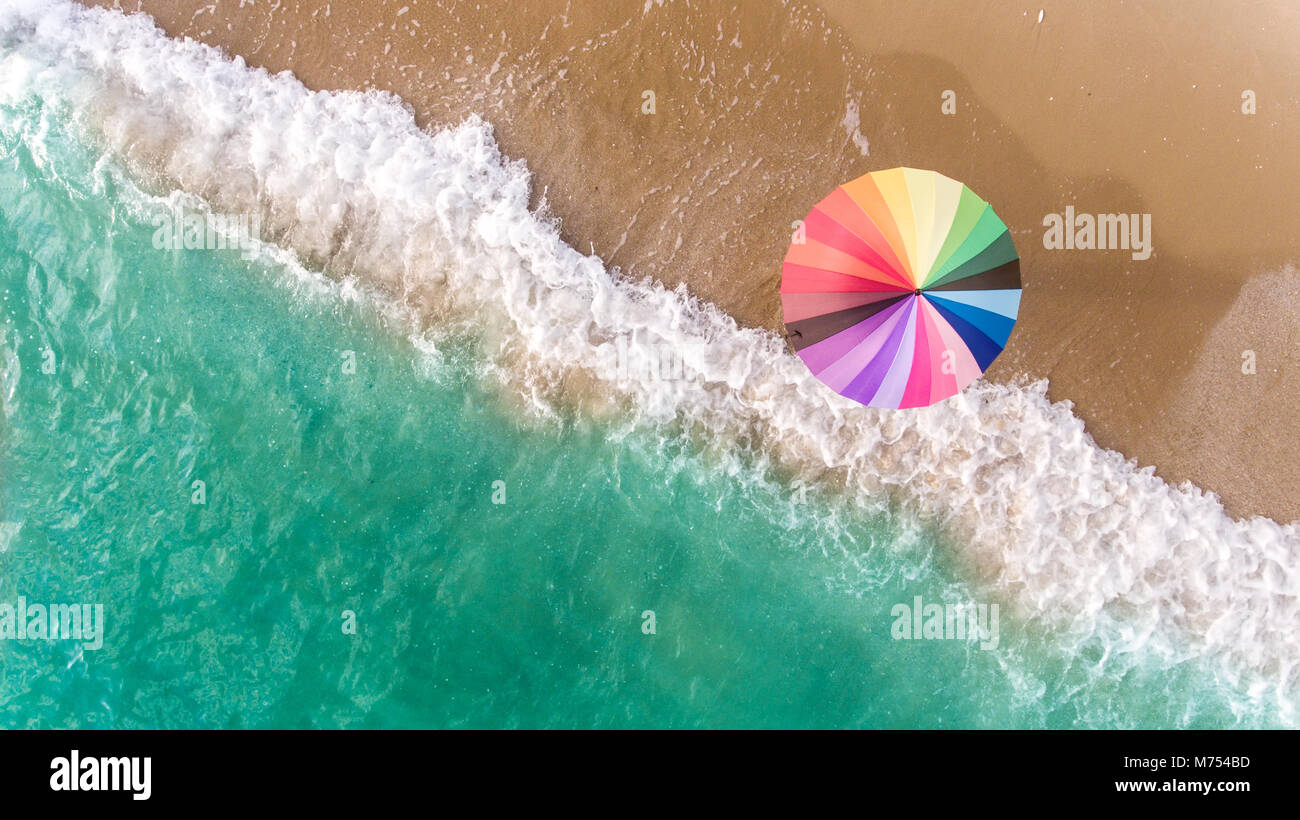 Colorful of umbrella on the beach and foam of sea wave from top eye ...