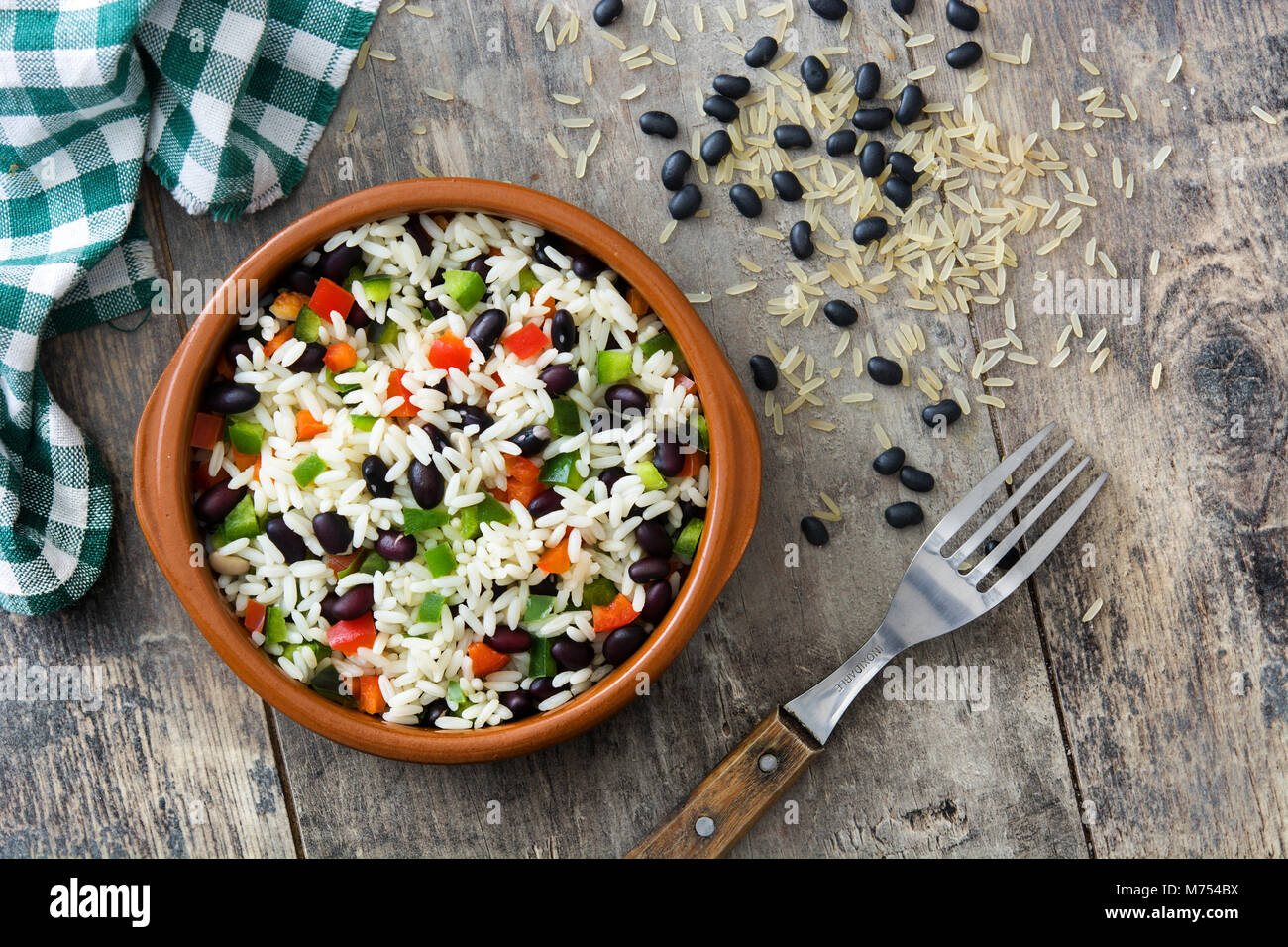 Traditional cuban rice, black beans and pepper on wooden table ...