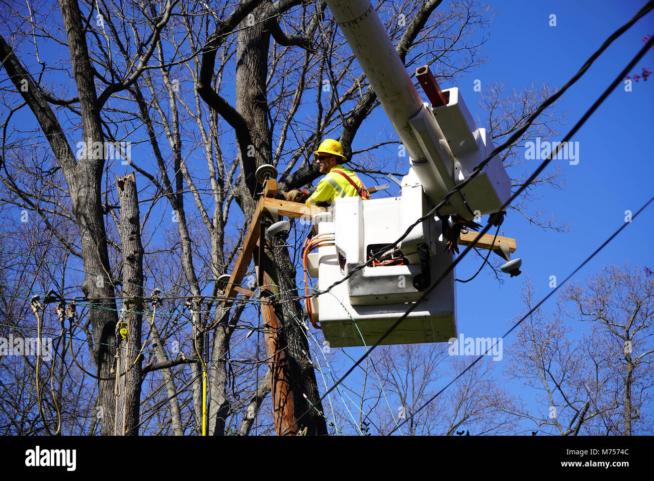 Electrical power crew works to restore power after an intense wind ...