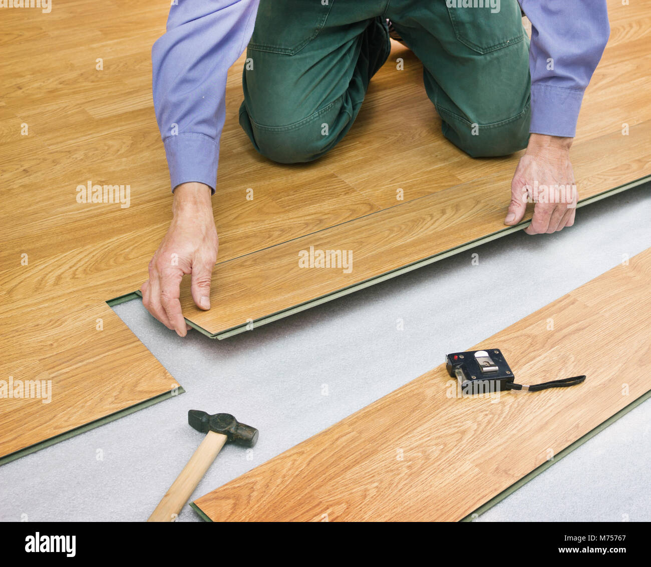 Man makes laying laminated panels color of wood Stock Photo - Alamy