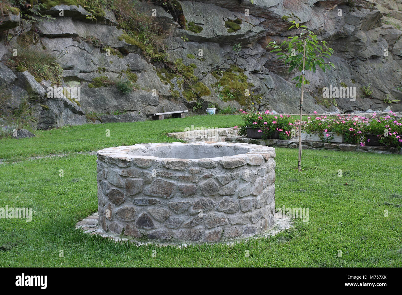 water well in garden in background rock Stock Photo - Alamy