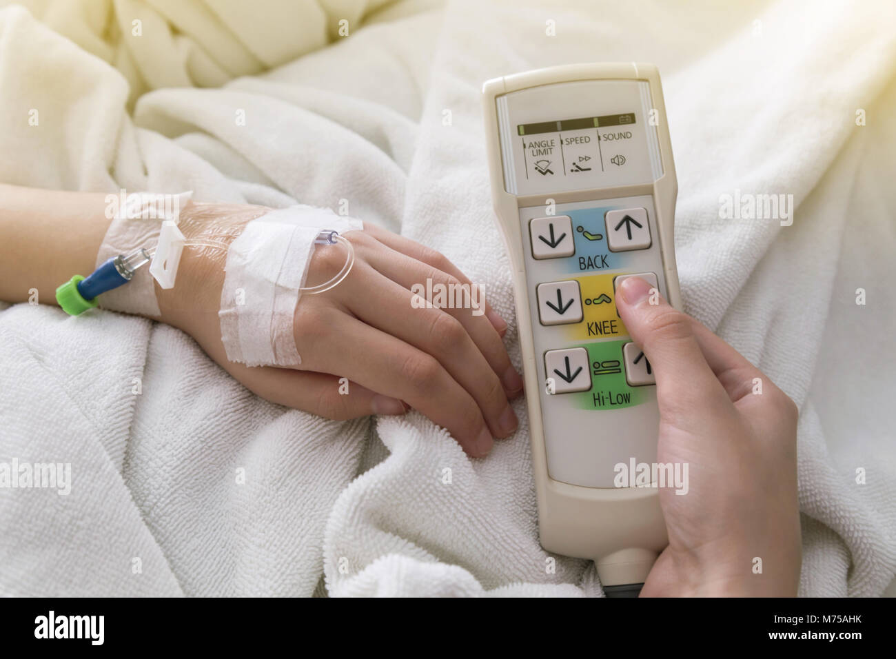 female patient adjust the height of the patient bed by press the button ...