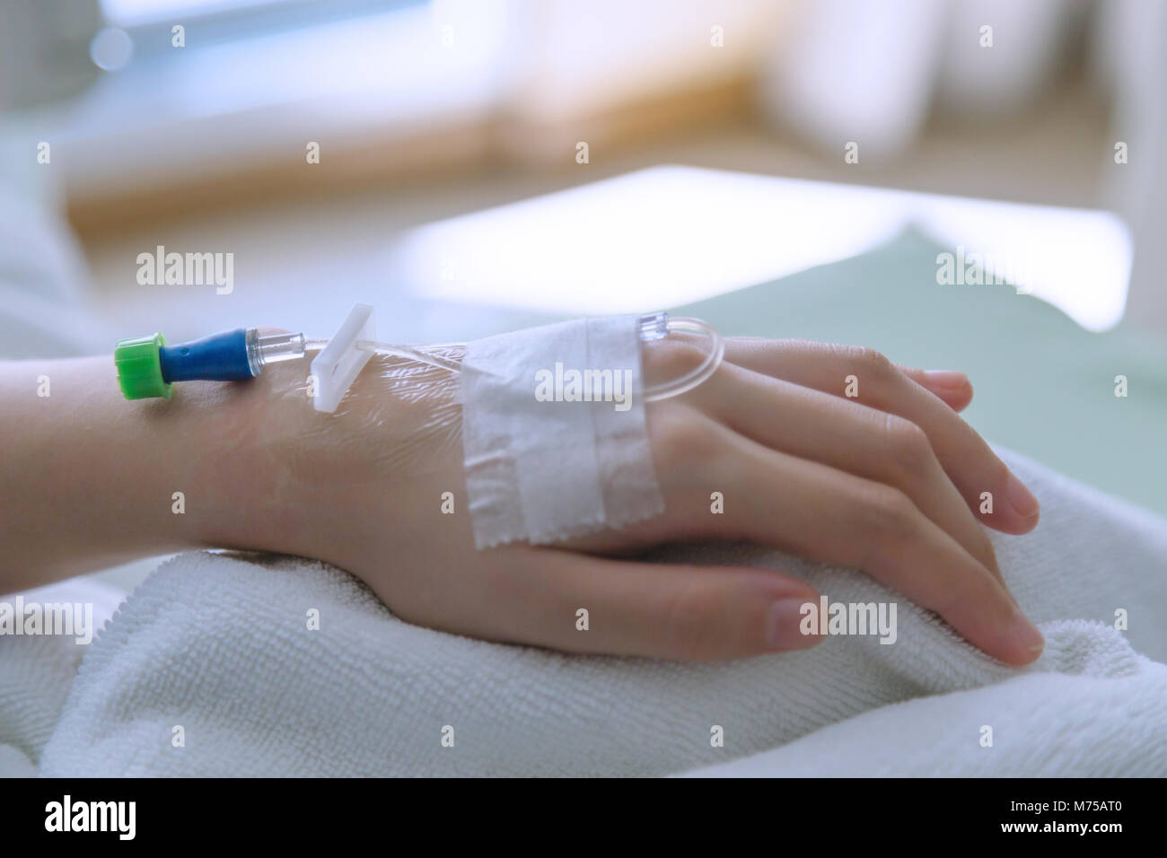 saline tube on woman patient's hand in the patient room after surgery ...