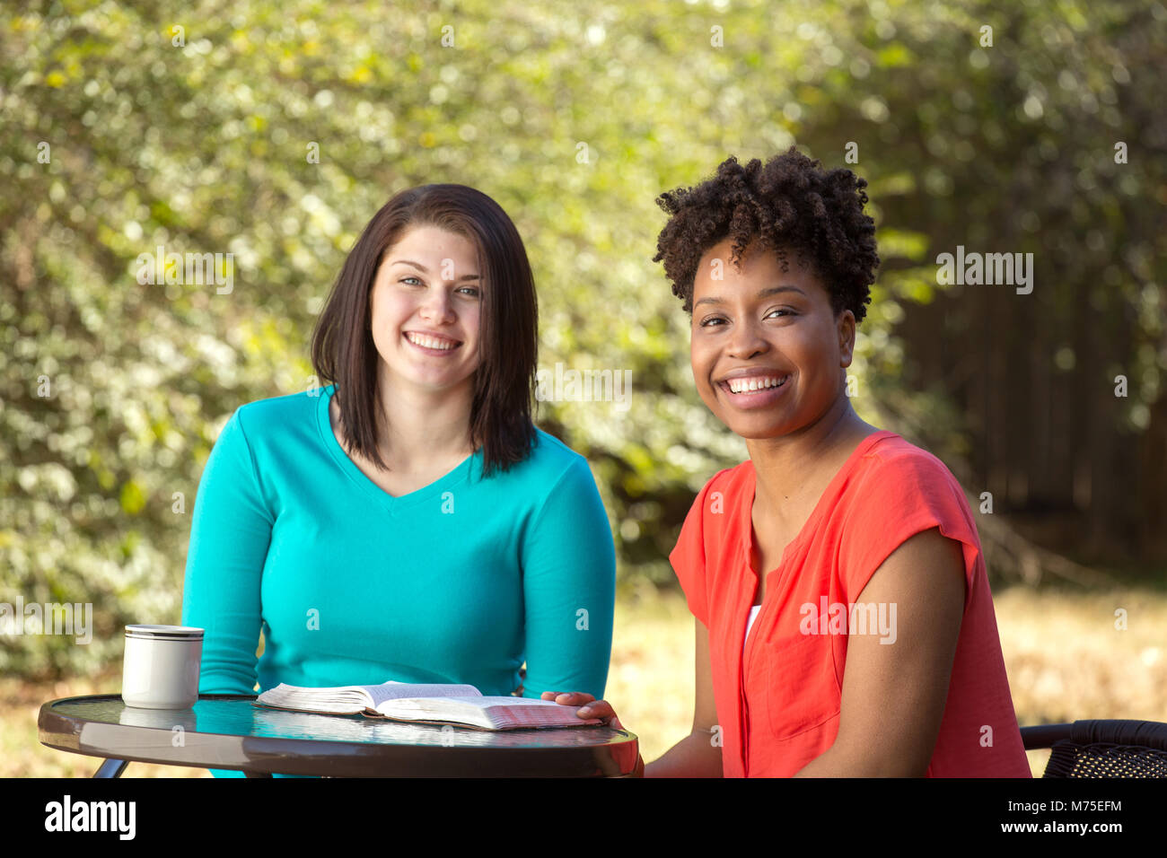 Two women reading bible together hi-res stock photography and images ...