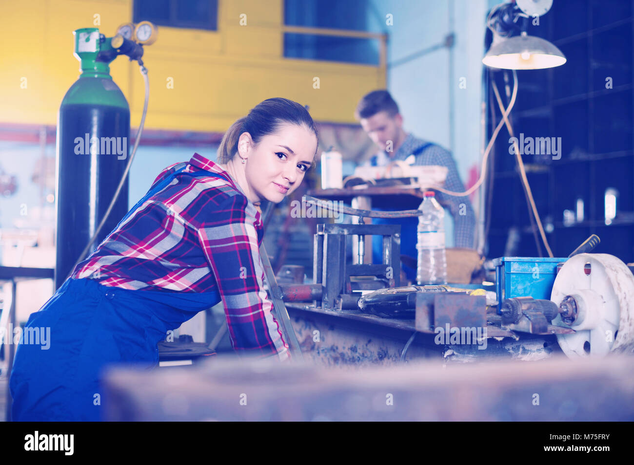 Portrait of positive smiling girl worker who is holding adjustable ...