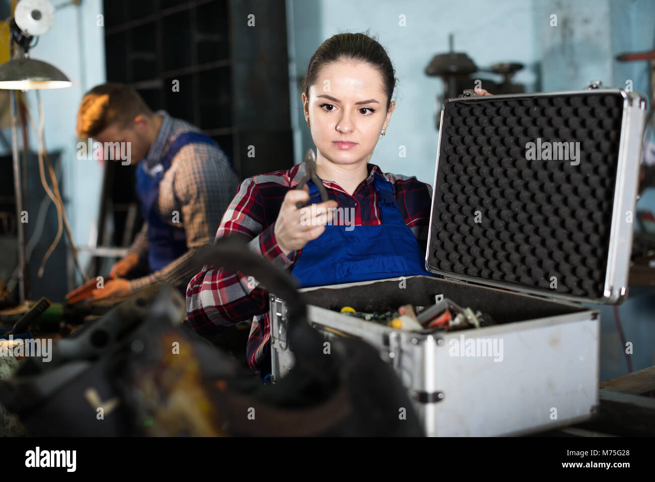 Young woman master is looking tools in box in workplace Stock Photo - Alamy